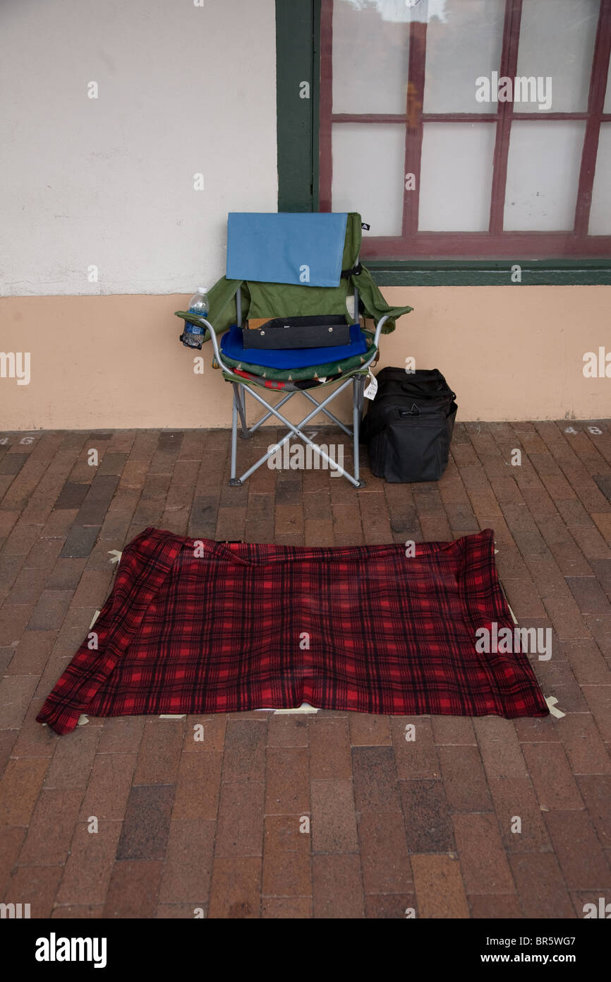 Street vendor's chair and blanket set up along sidewalk Stock Photo - Alamy