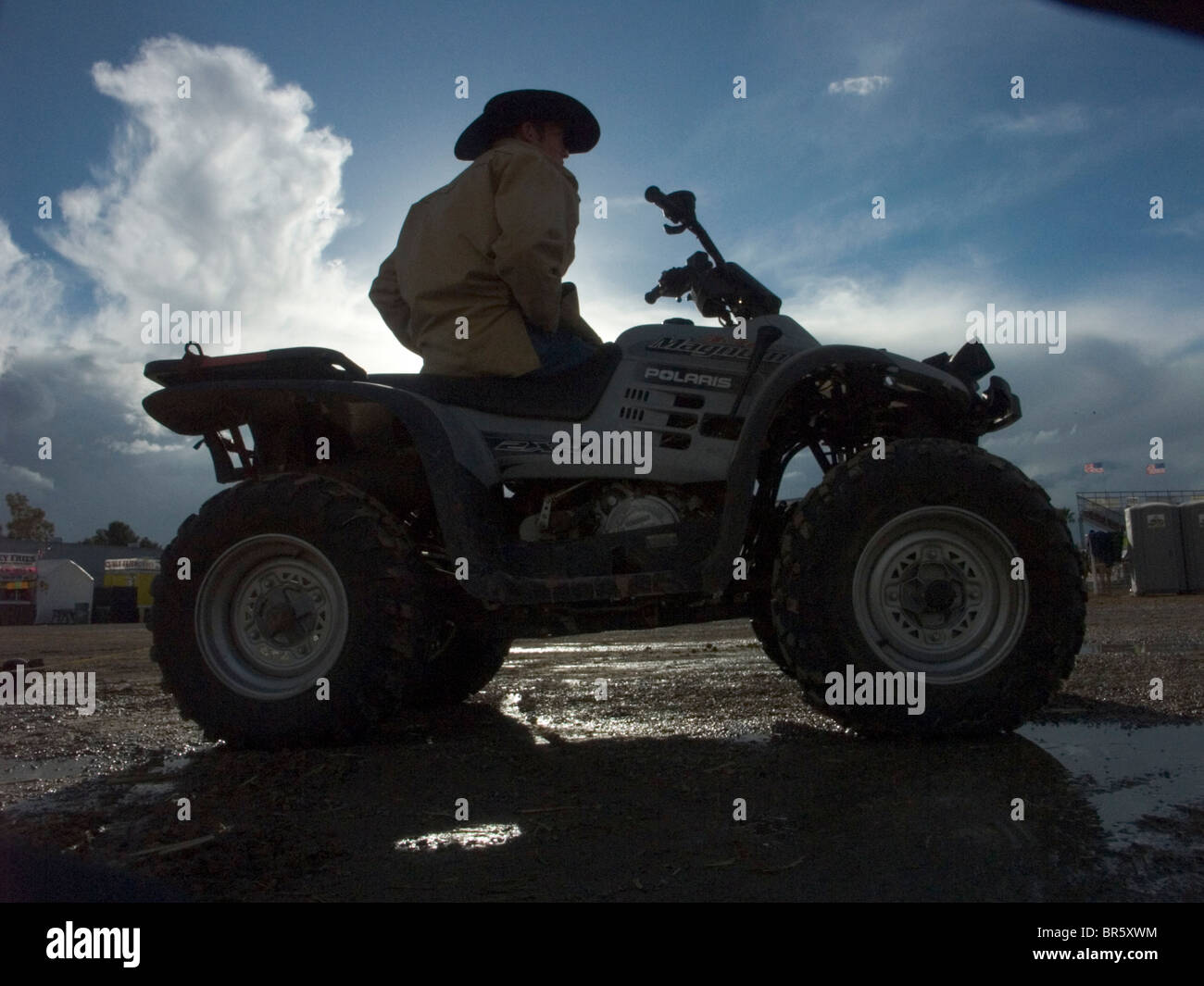 A cowboy sits on an all terrain vehicle Stock Photo - Alamy