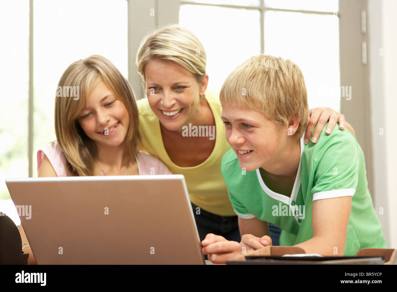 Mother And Teenage Children Using Laptop At Home Stock Photo - Alamy