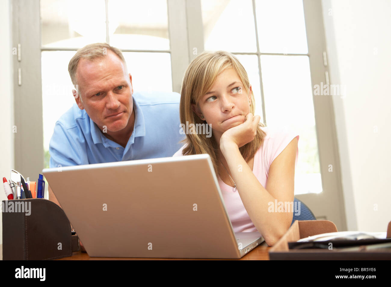 Angry Father And Teenage Daughter Using Laptop At Home Stock Photo - Alamy
