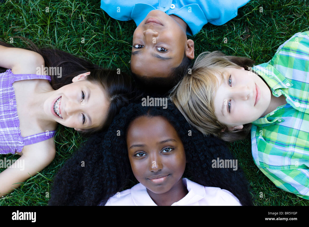 Children laying in formation on grass Stock Photo - Alamy