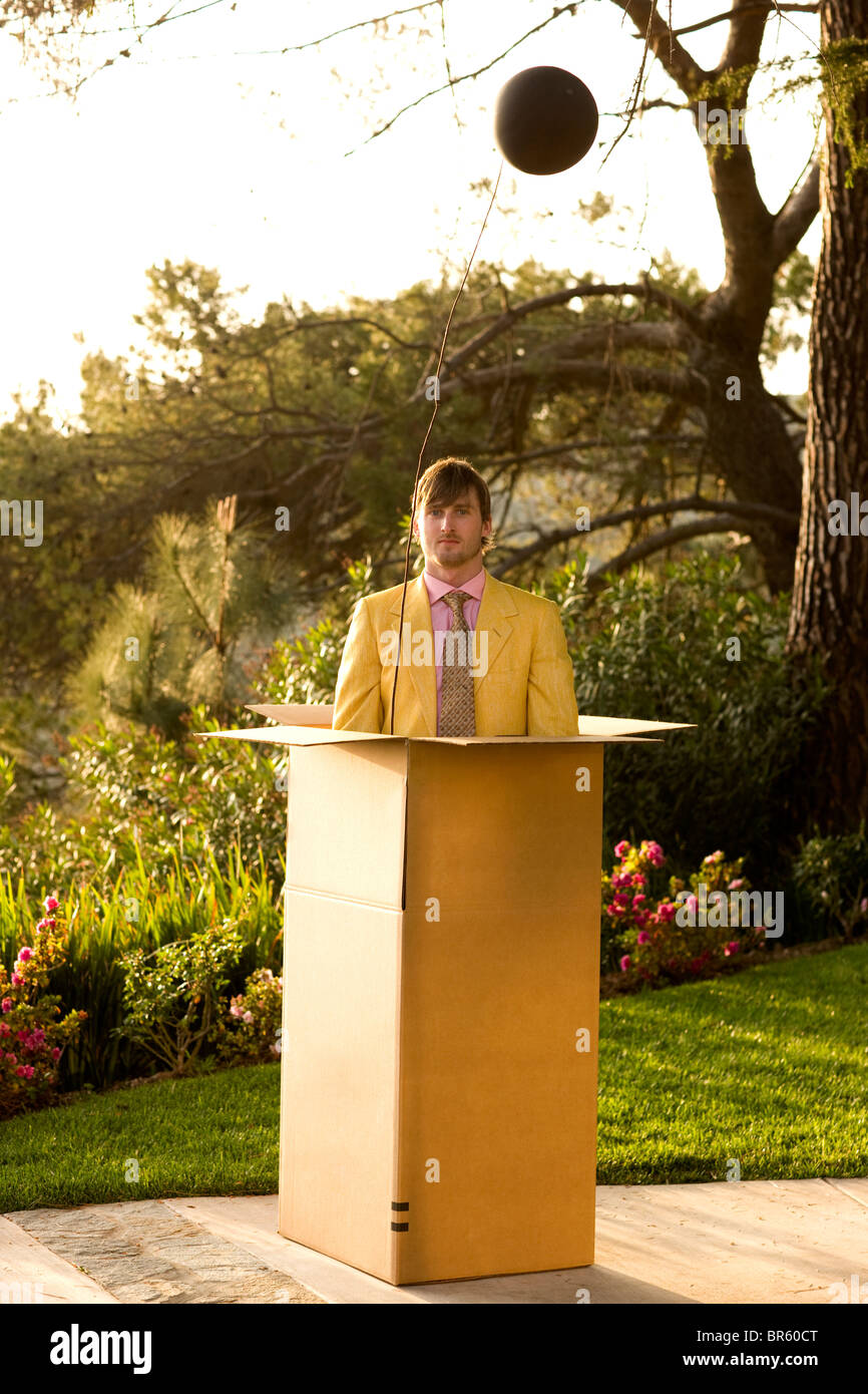 Caucasian man standing in large cardboard box outdoors Stock Photo - Alamy