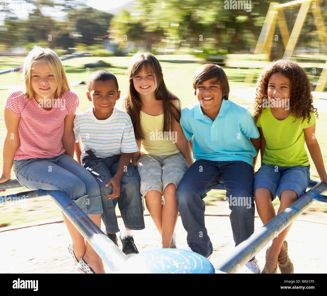 Group Of Children Riding On Roundabout In Playground Stock Photo - Alamy