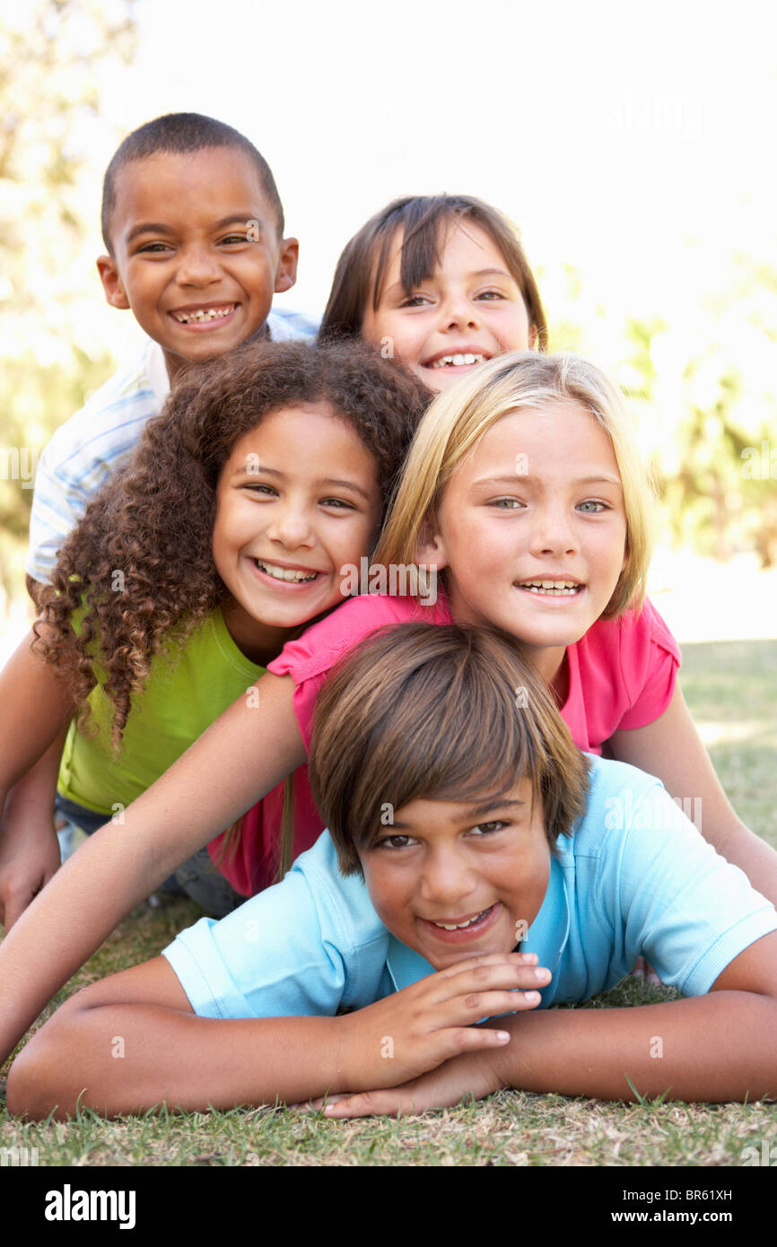 Group Of Children Piled Up In Park Stock Photo - Alamy