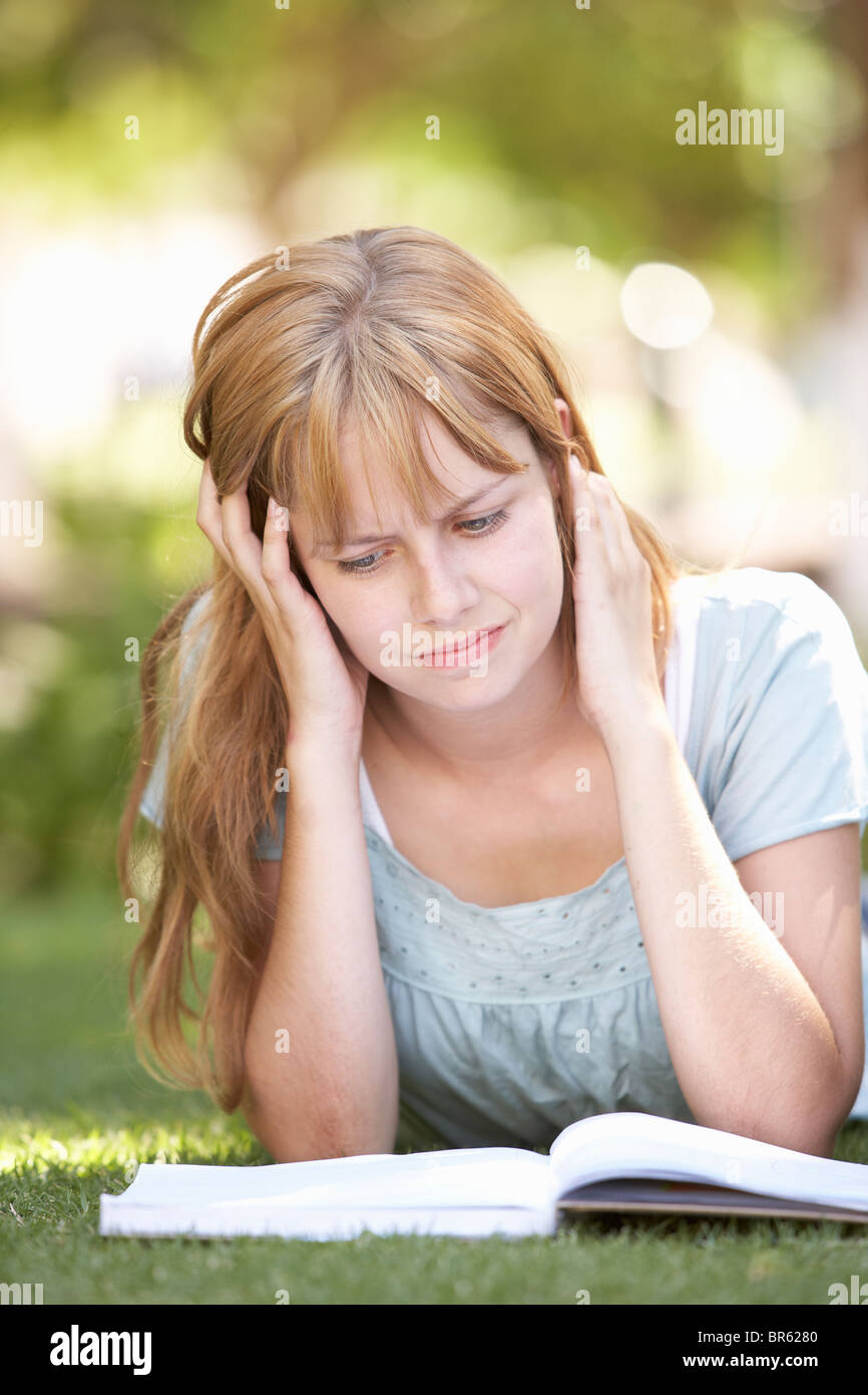 Female Teenage Student Studying In Park Looking Puzzled Stock Photo - Alamy