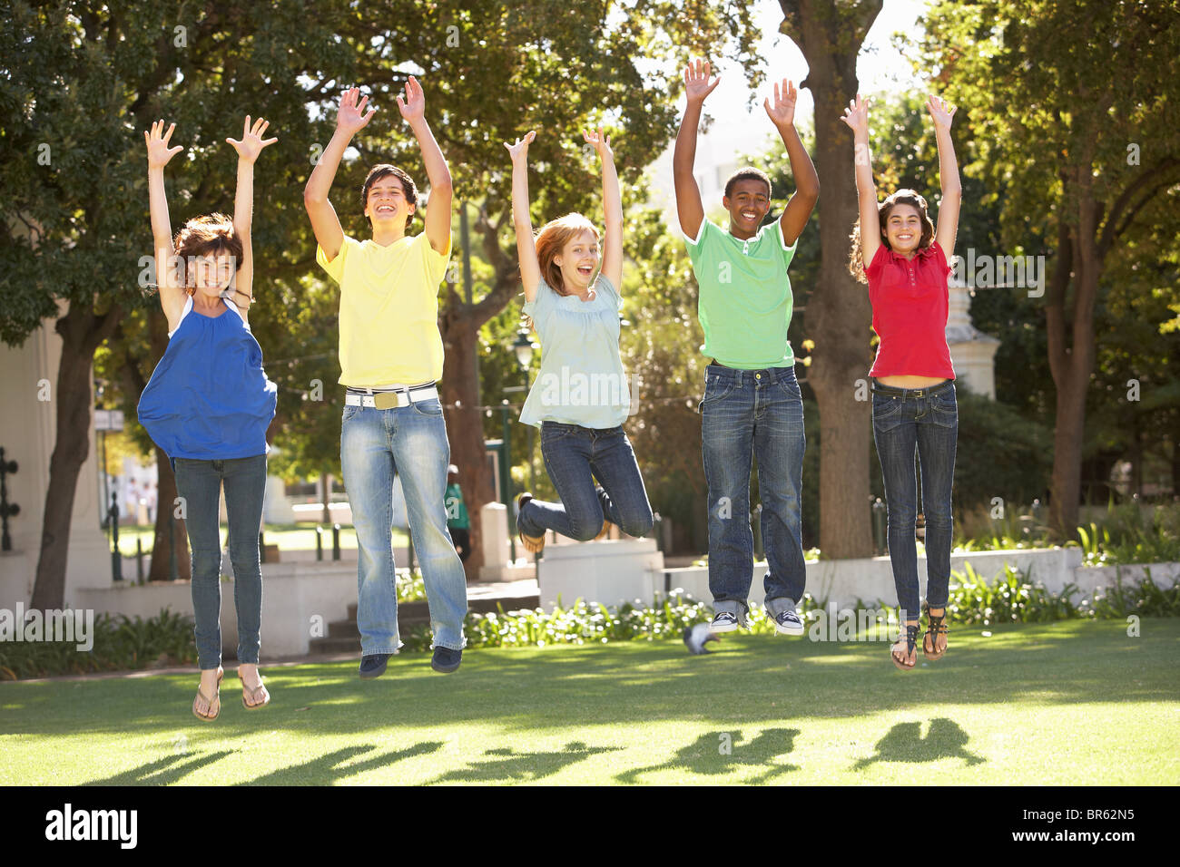 Group Of Teenagers Jumping In Air In Park Stock Photo - Alamy