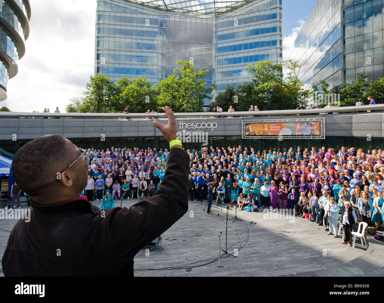 Michael Harper conducting a massed choir at the Thames Festival in ...