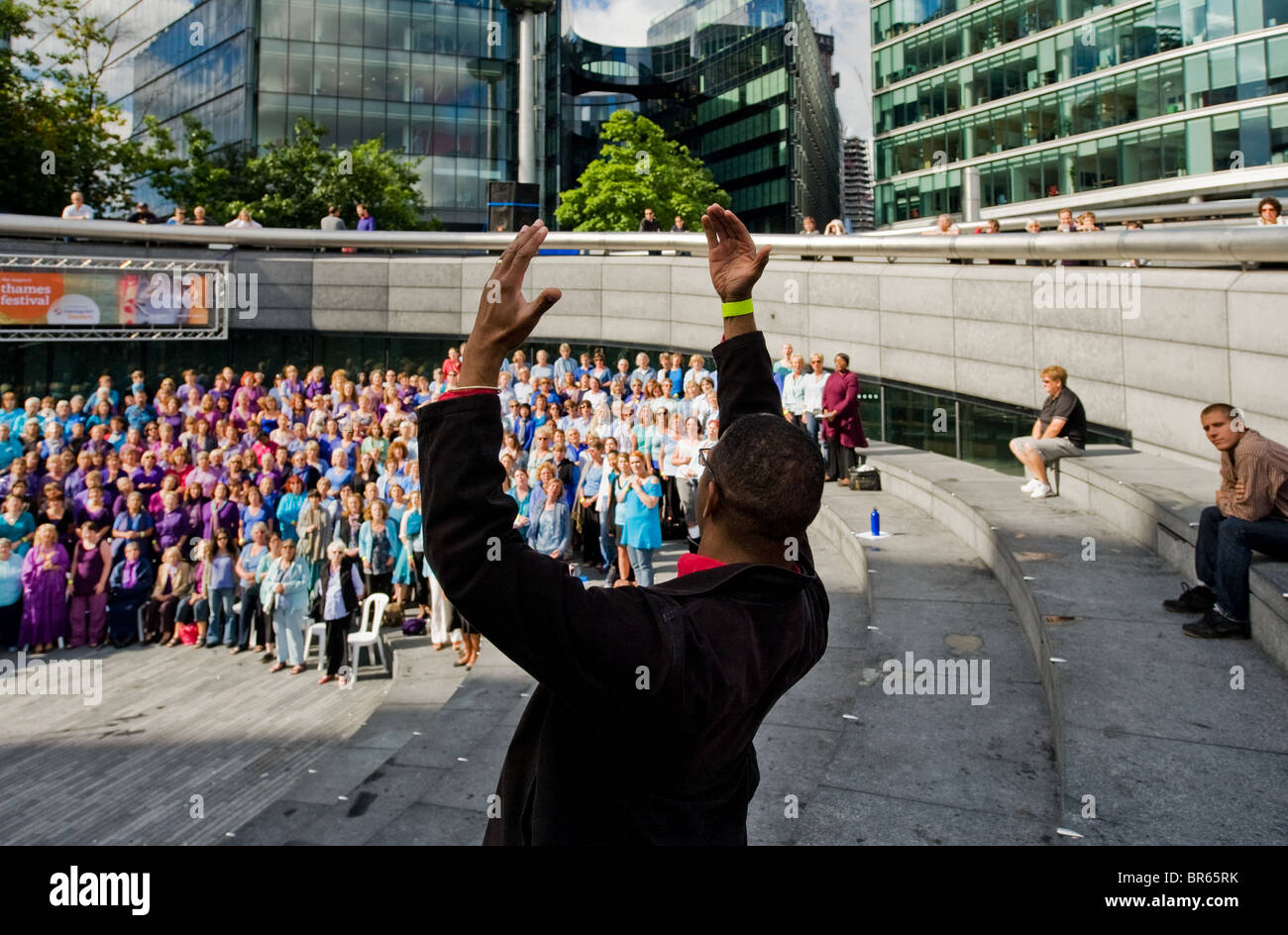 Michael Harper conducting a massed choir at the Thames Festival in ...
