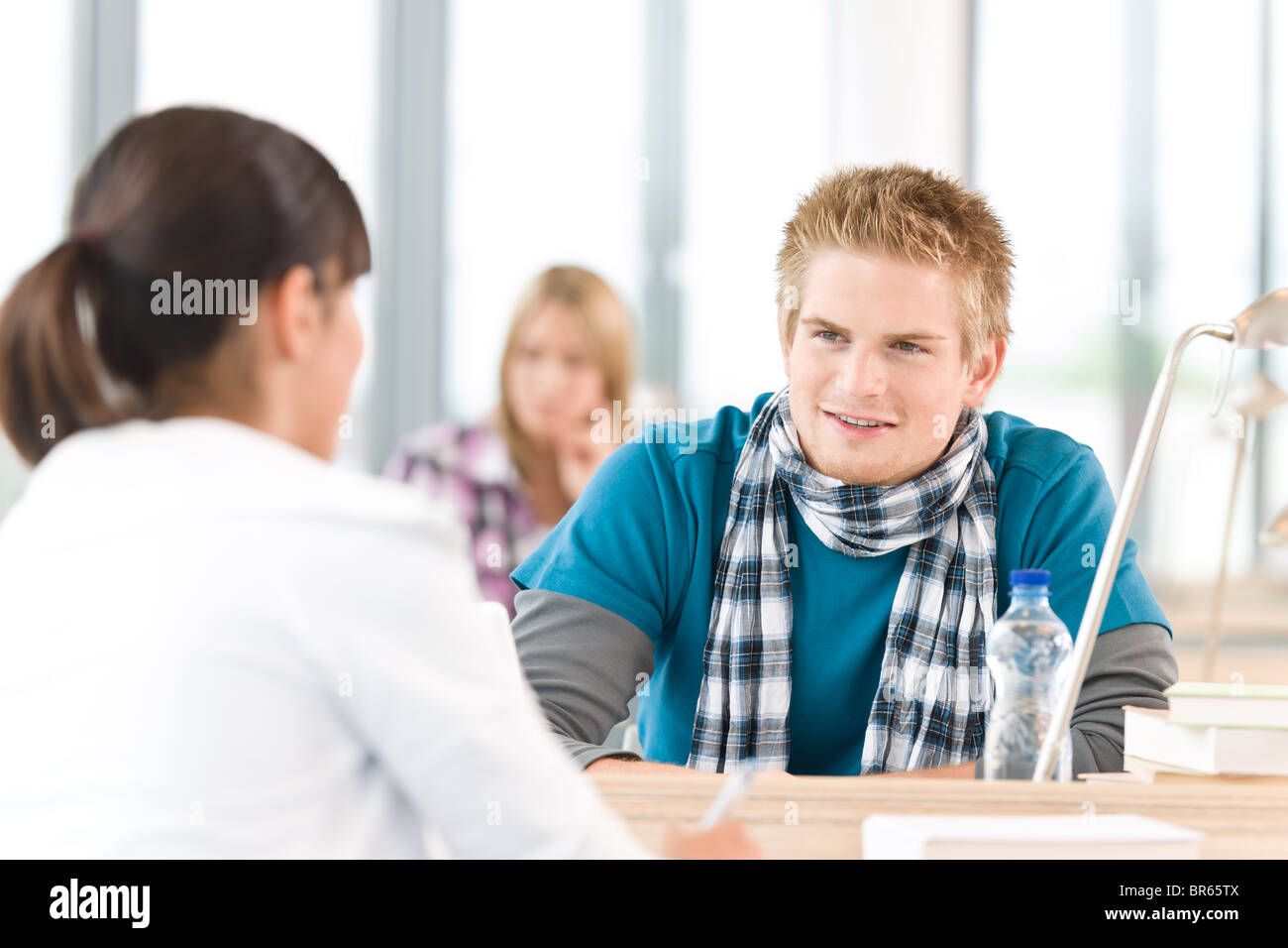 Three high school students in classroom studying with books Stock Photo ...