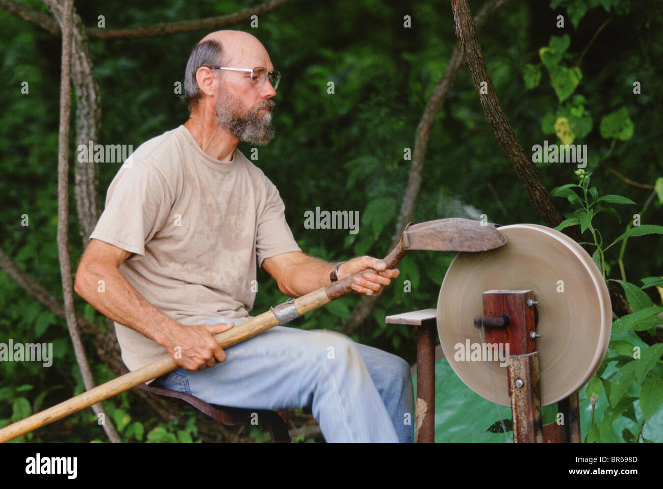 A man sharpening shovels to be used at an archaeological dig at the Big ...