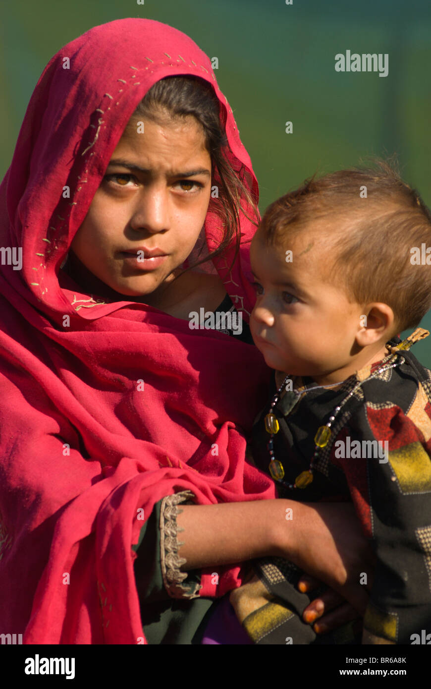 A Pashtun girl holds her younger brother in the Meira camp for ...