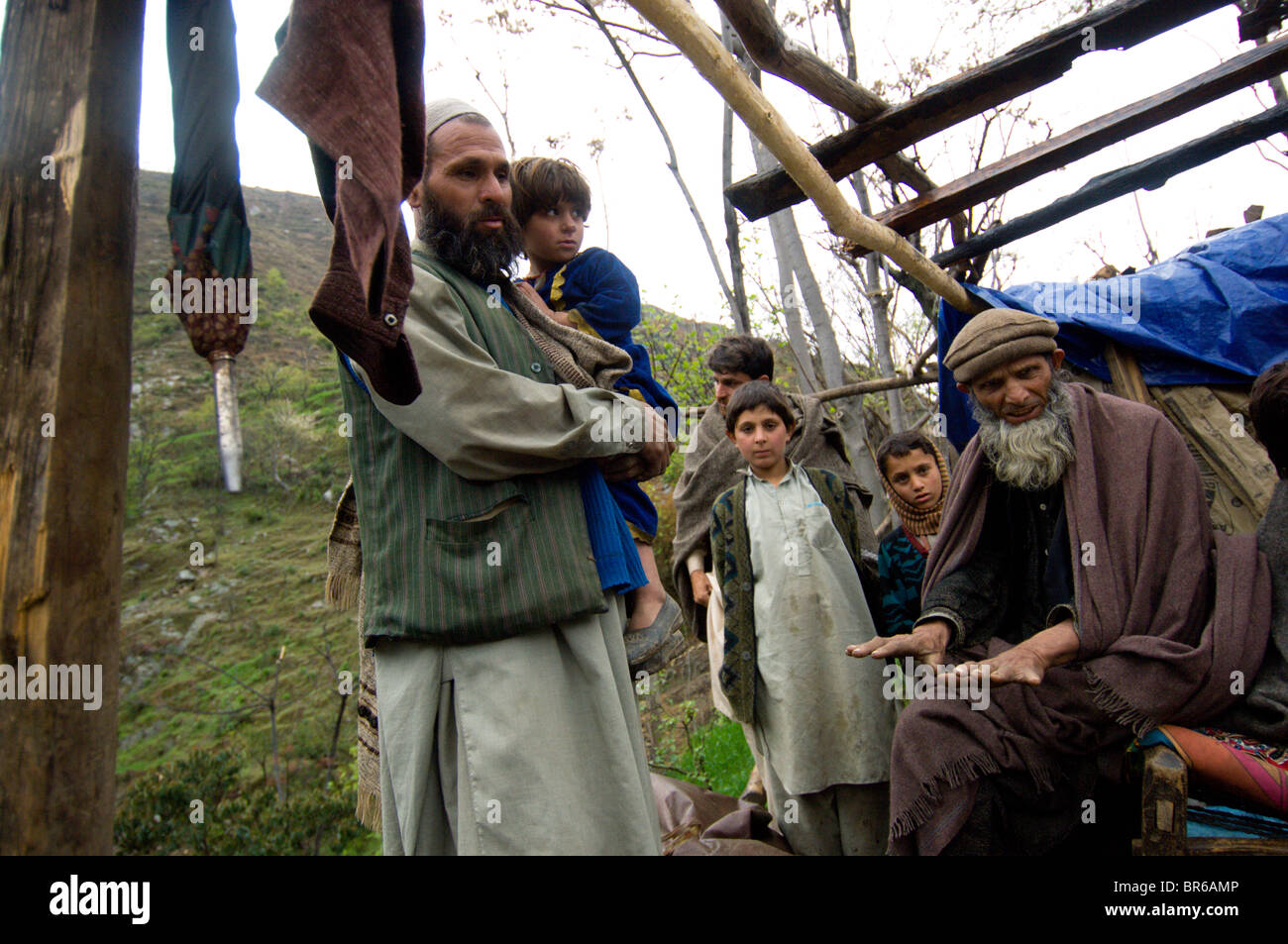 A Pashtun family who have just arrived back to their ruined mountain ...