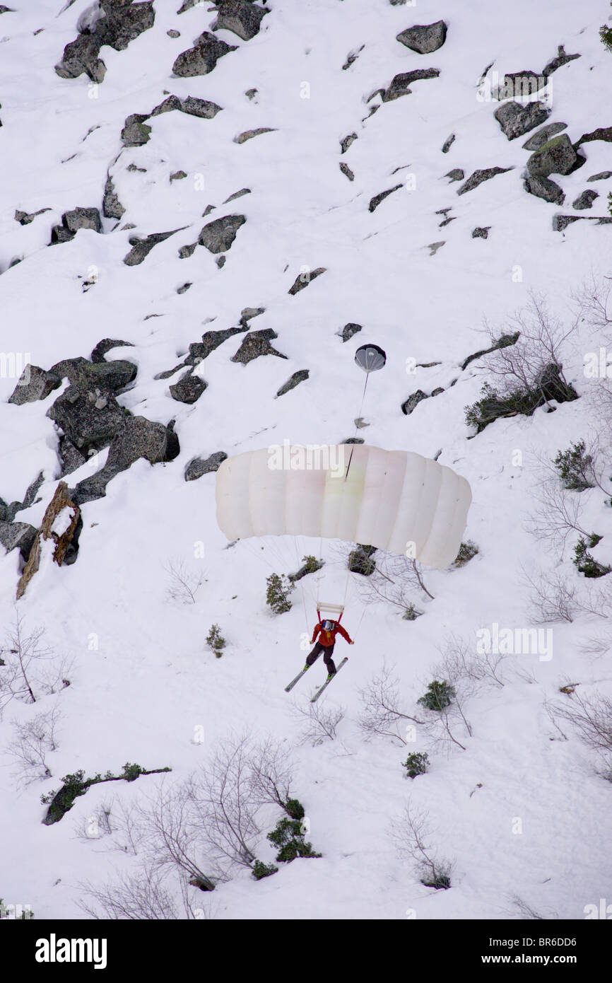 A male ski BASE jumper opens his shoot just before his safe landing ...
