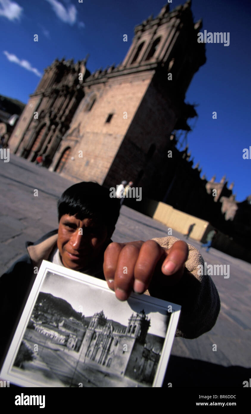 A native Peruvian man shows a black and white photo of a cathedral ...