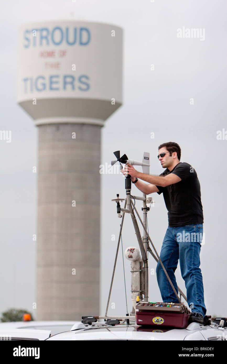 A scientist with Project Vortex 2 cleans the anemometer mounted to his ...