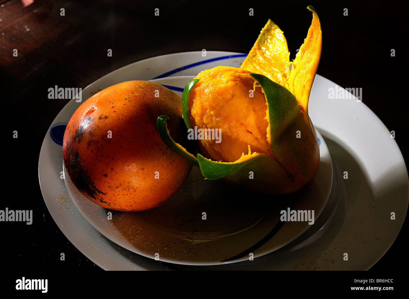2 mangos on a plate Stock Photo - Alamy