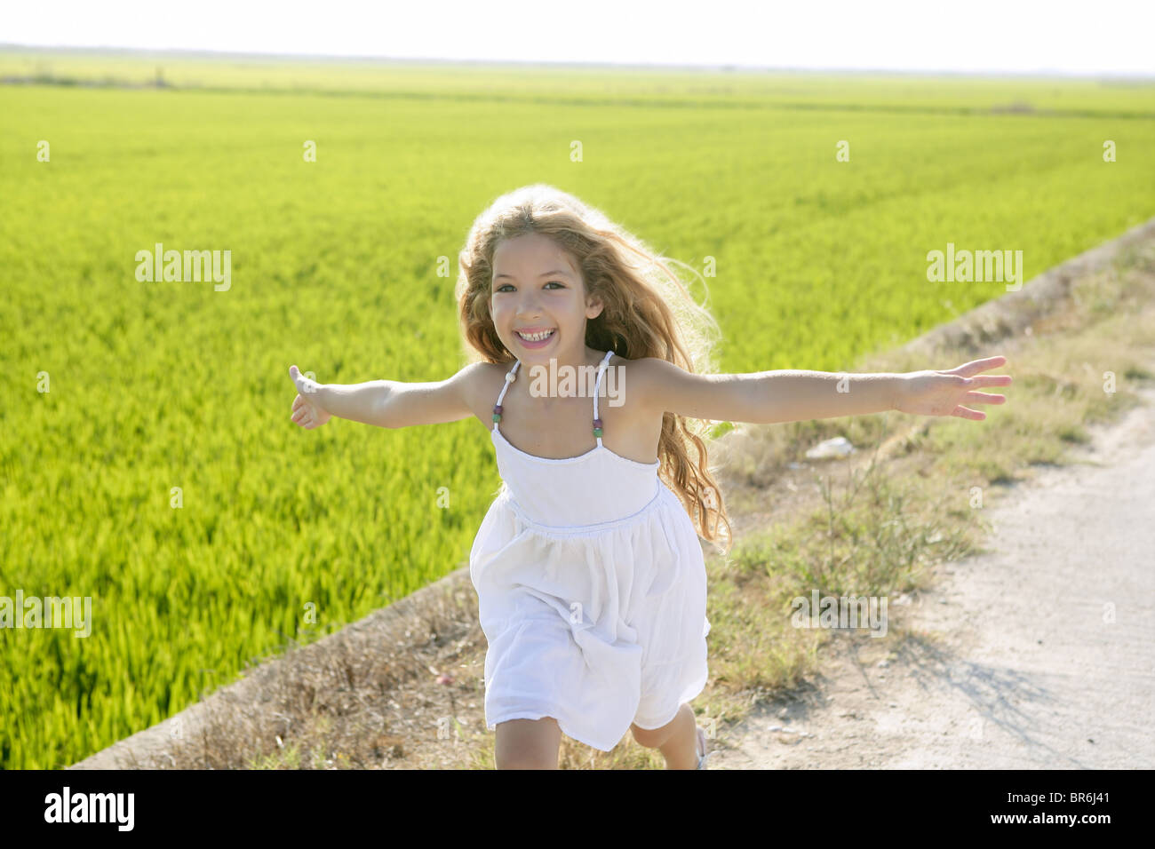 running open arms little happy girl green meadow field track Stock ...