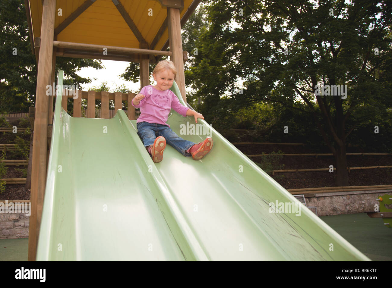 child on playground . playing on slide Stock Photo - Alamy
