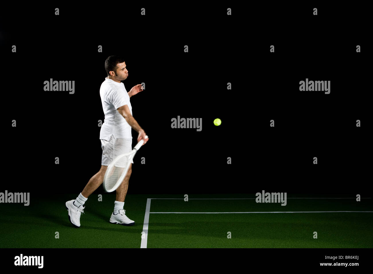 A tennis player about to a hit a ball, studio shot, portrait Stock ...
