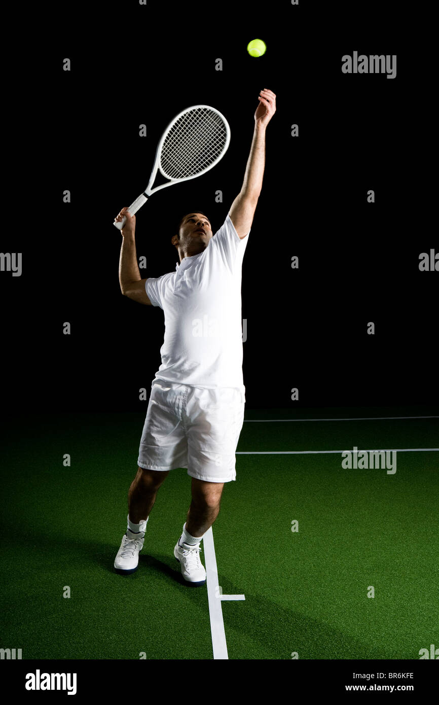 A tennis player serving a ball, portrait, studio shot Stock Photo - Alamy