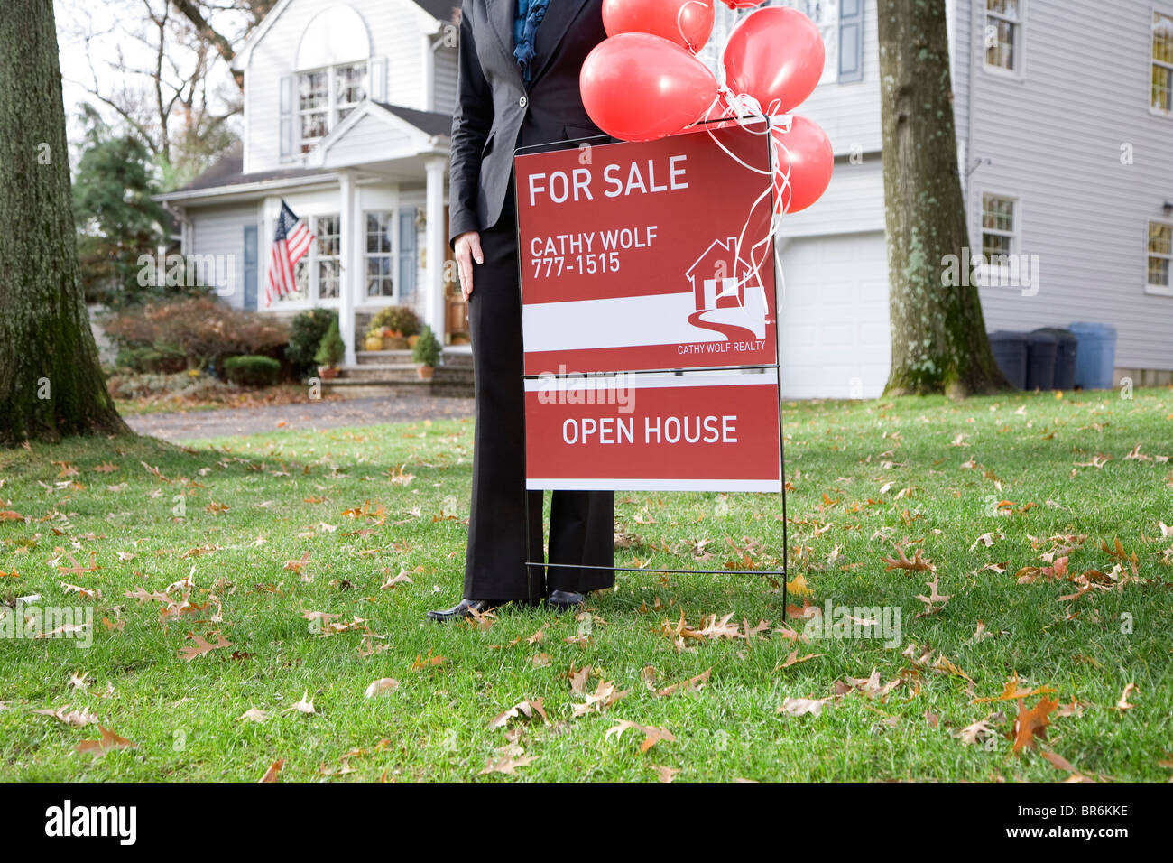 A real estate agent standing by a FOR SALE sign Stock Photo - Alamy