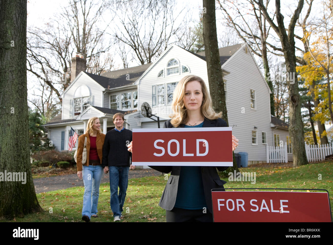 A real estate agent holding a SOLD sign Stock Photo - Alamy