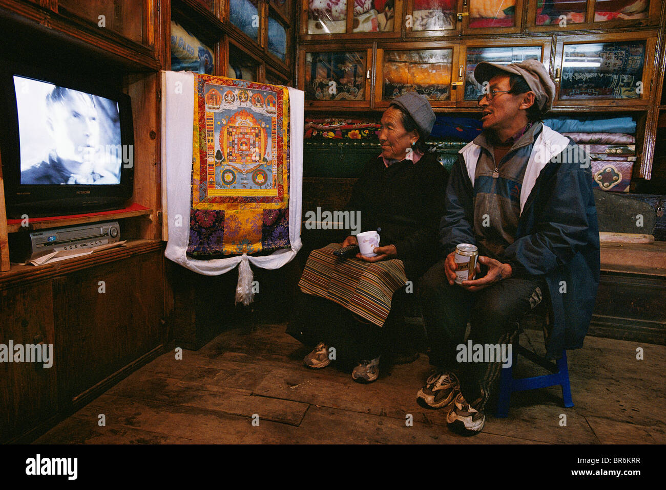 Two Sherpa men sit inside a small tea house and watch American movies ...