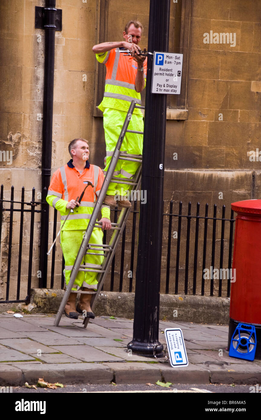 Council workers in the city of Bath put up parking restriction notices ...