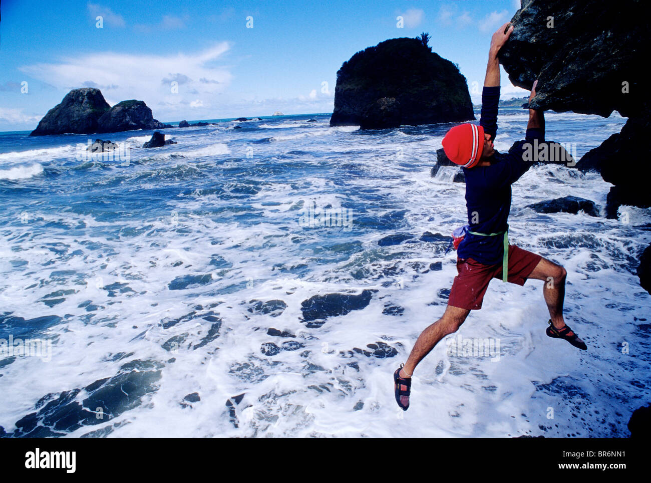 A boulderer in a cave above the ocean in Northern California Stock ...
