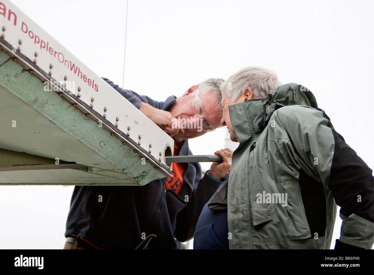 Scientists with Project Vortex 2 work on repairing the radar dish of a ...