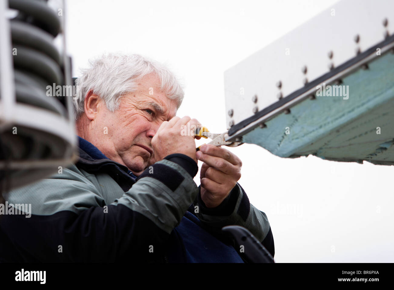 A scientist with Project Vortex 2 work on repairing the radar dish of a ...