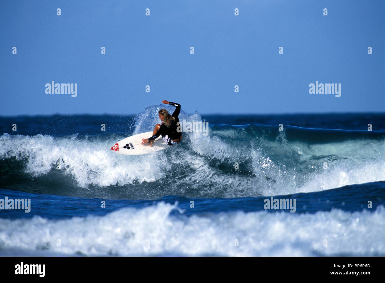 A female surfer surfing on a choppy coastline Stock Photo - Alamy