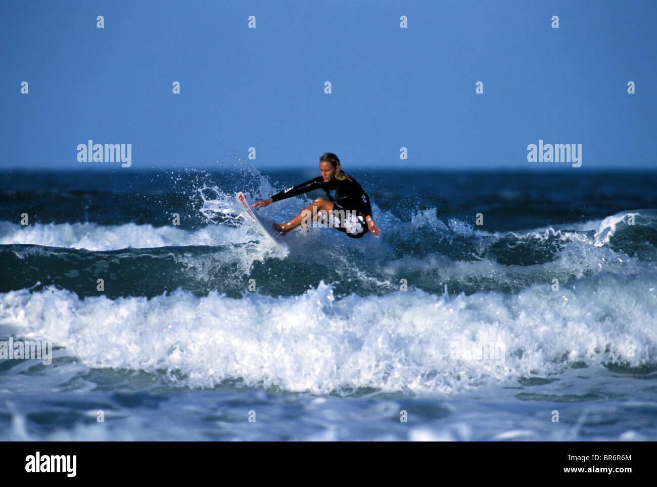 A female surfer surfing on a choppy coastline Stock Photo - Alamy