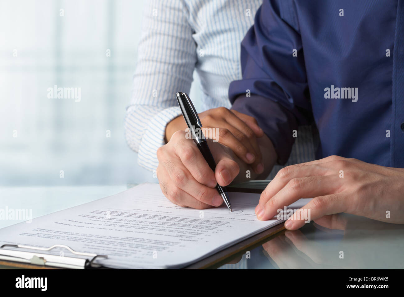 Couple signing paper to symbolize agreement that need couple signature ...