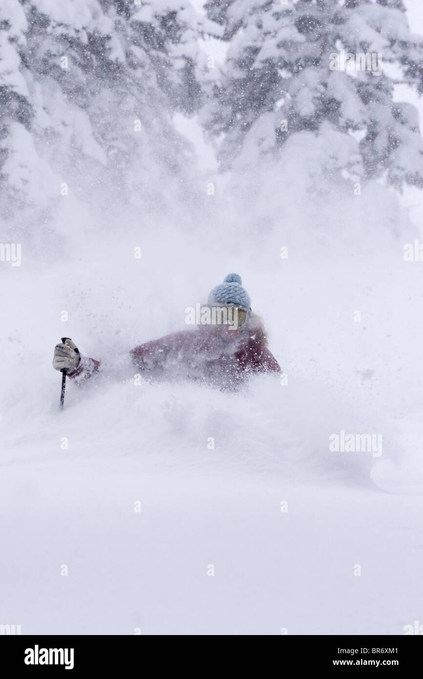 A woman skiing deep powder snow in a storm Alpine Meadows in Lake Tahoe ...