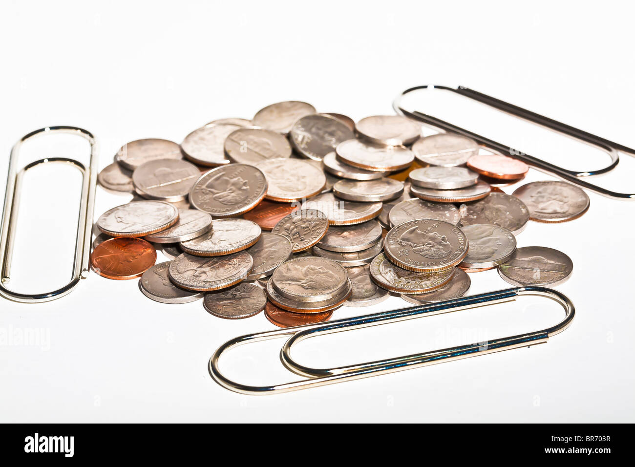 small change - pile of coins with giant paper clips Stock Photo - Alamy
