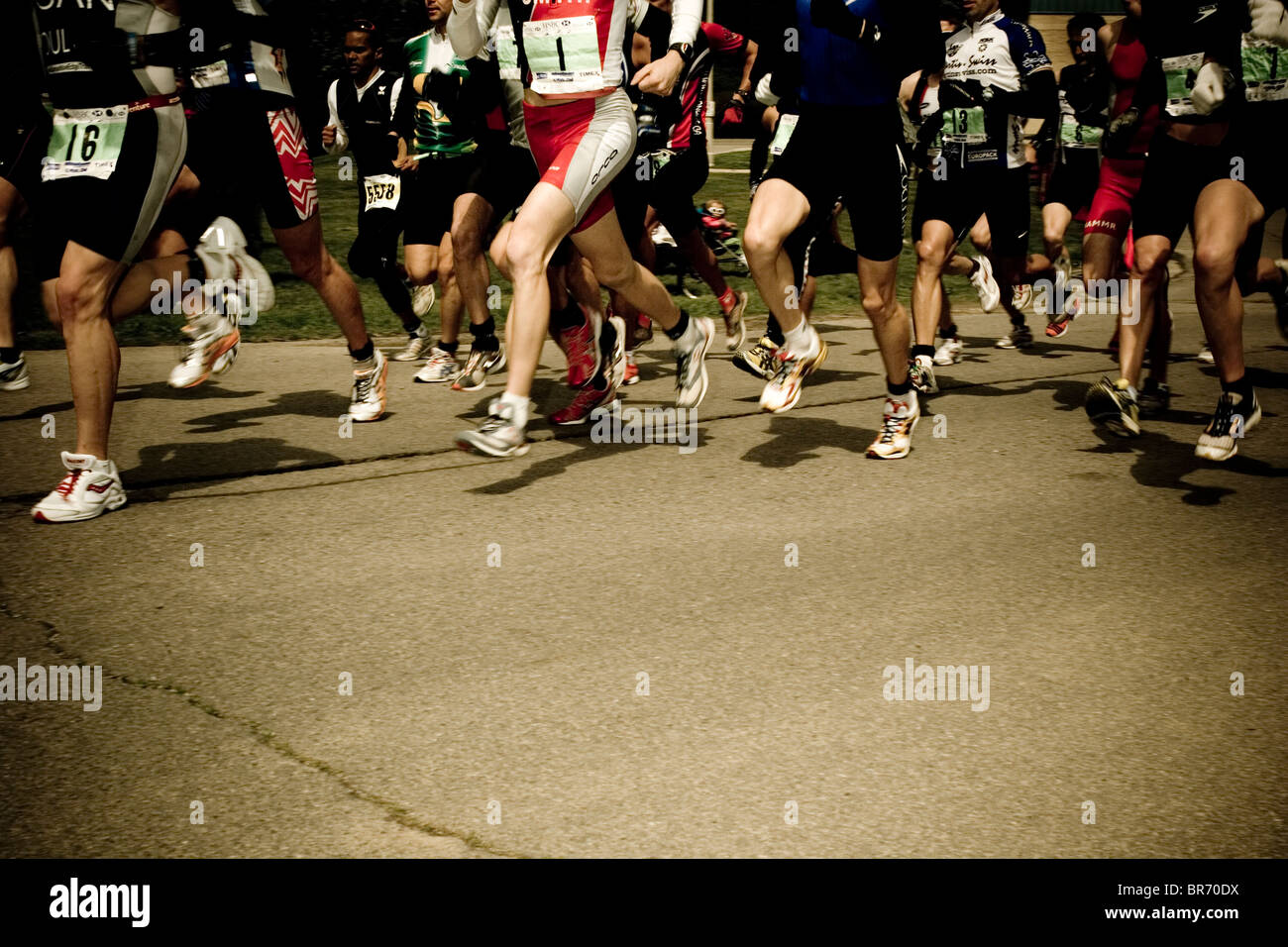 Competitors in a triathlon race sprinting from the start line in ...