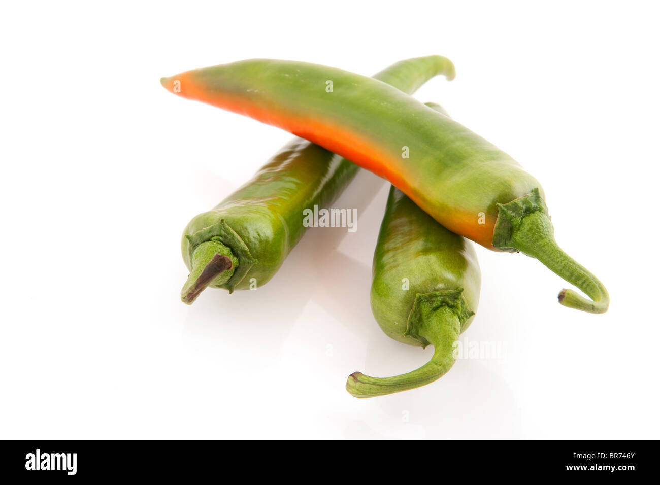Three green pepper with orange isolated over white Stock Photo - Alamy