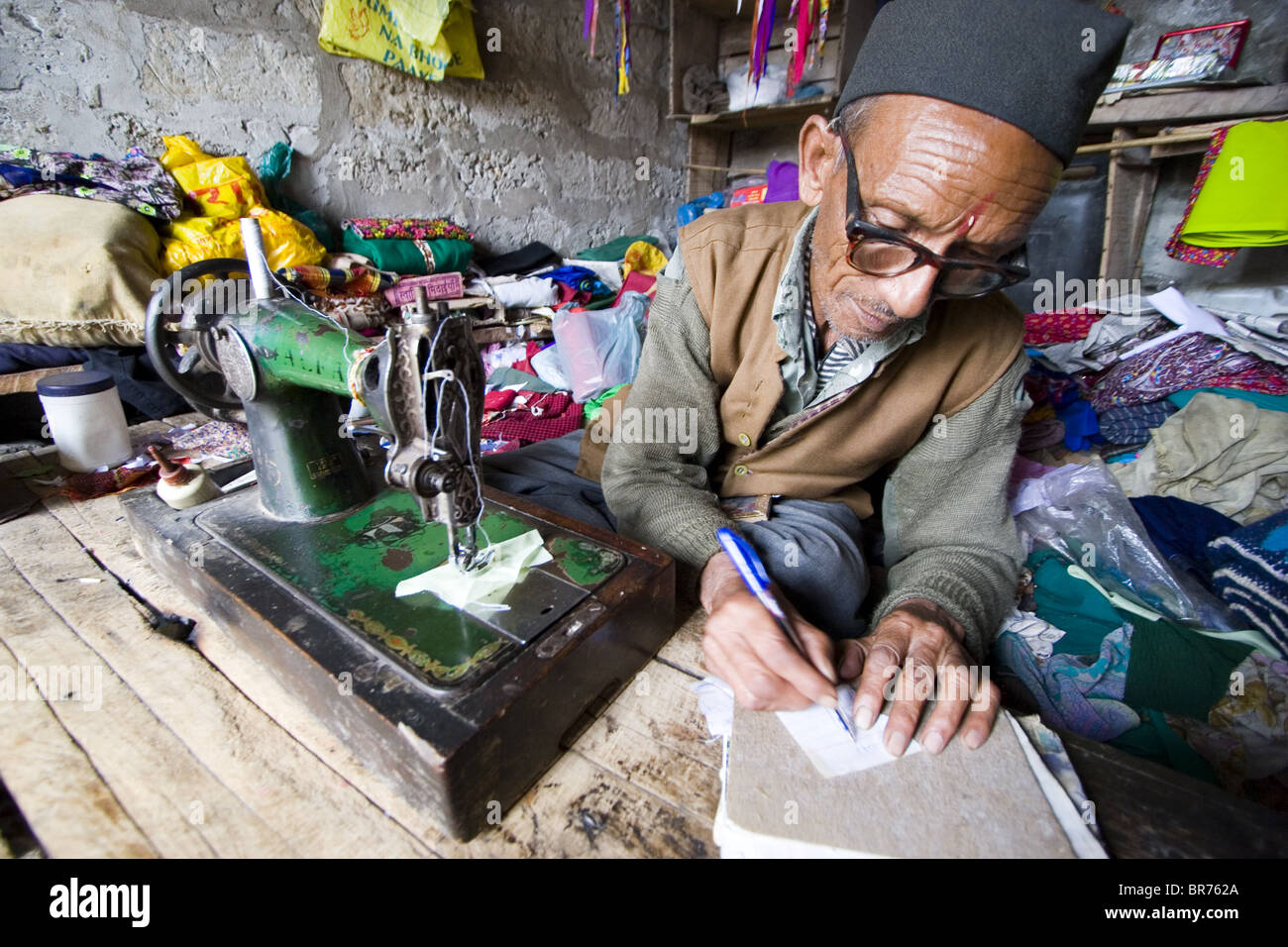 Man sewing goods in small village India Stock Photo - Alamy