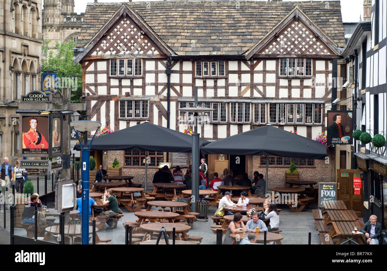 People drinking outside the Old Wellington Inn in Manchester city ...