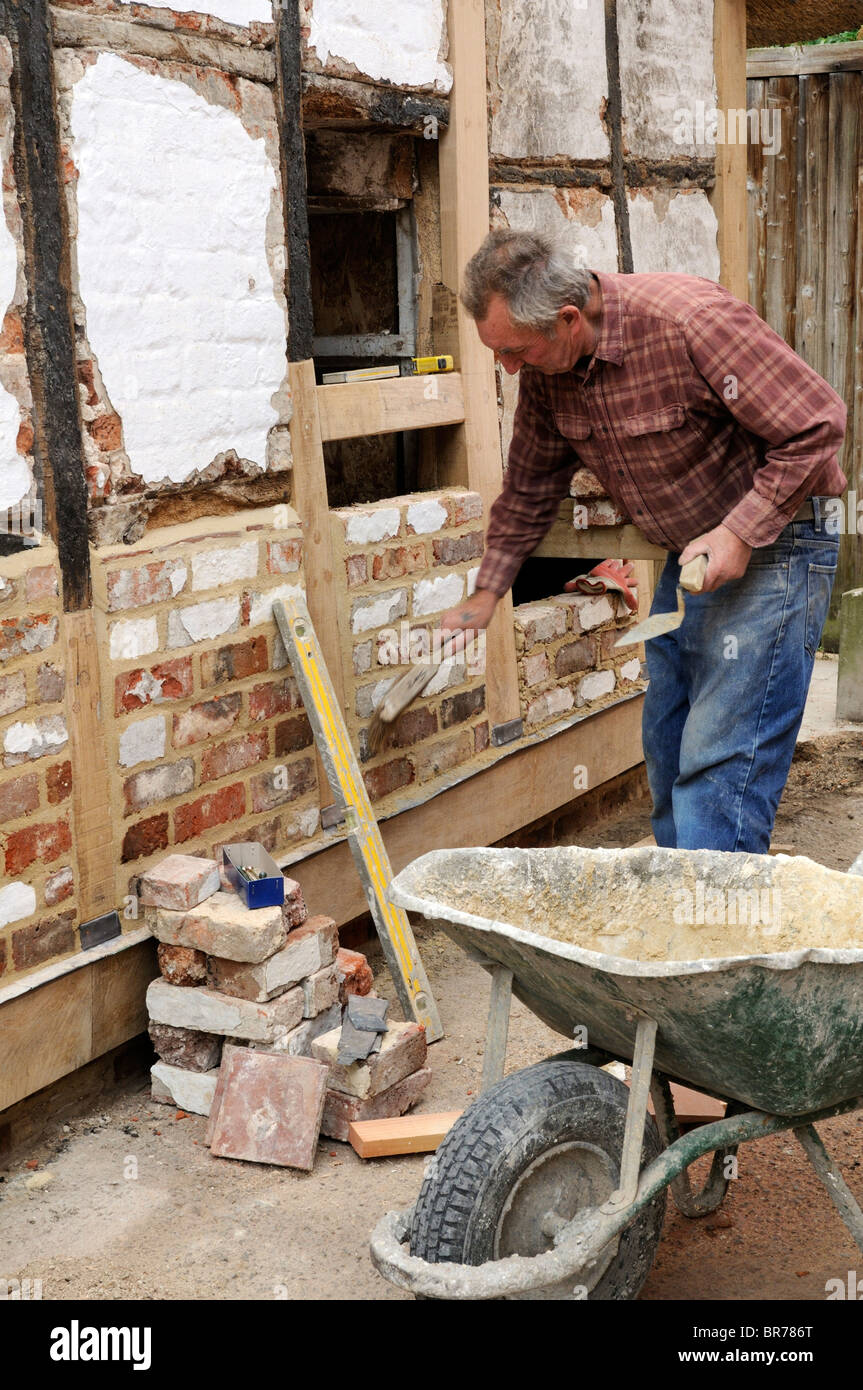 Renovating an old timber framed building bricklayer forming a new wall ...