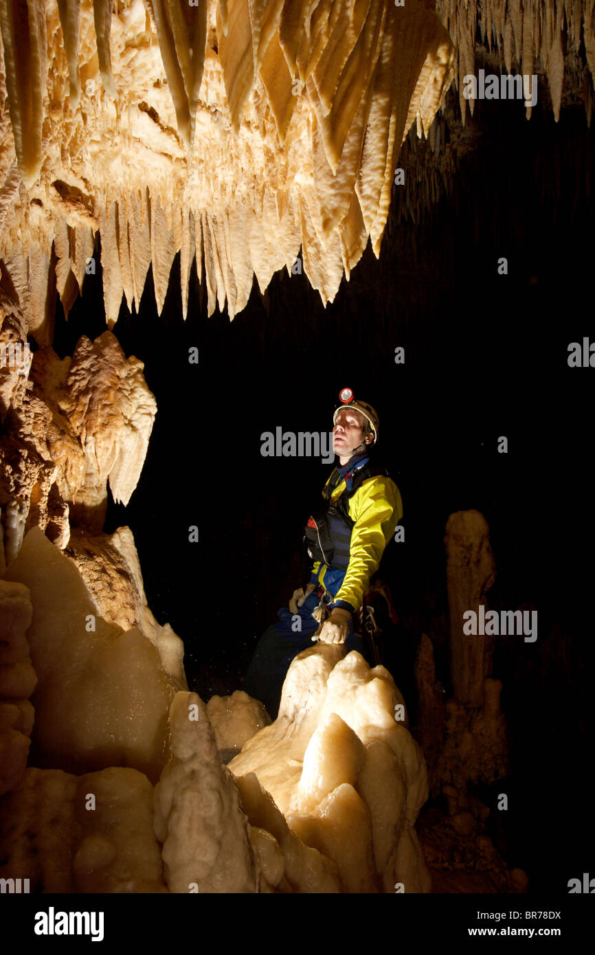 A cave explorer admires pretty formations in a cave in New Britain ...