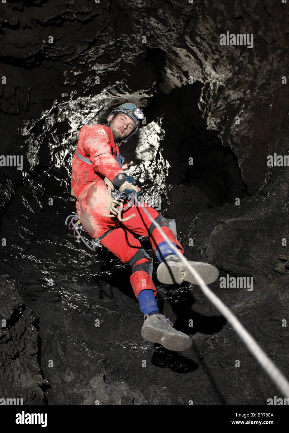 A cave explorer about to land after his rappel into a cave system in ...