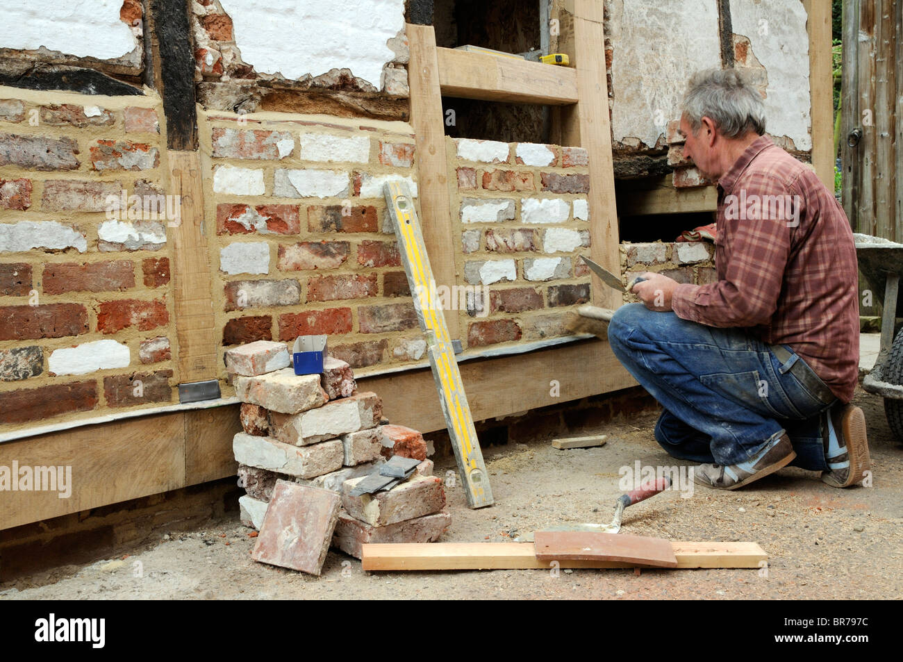 Renovating an old timber framed building bricklayer forming a new wall ...