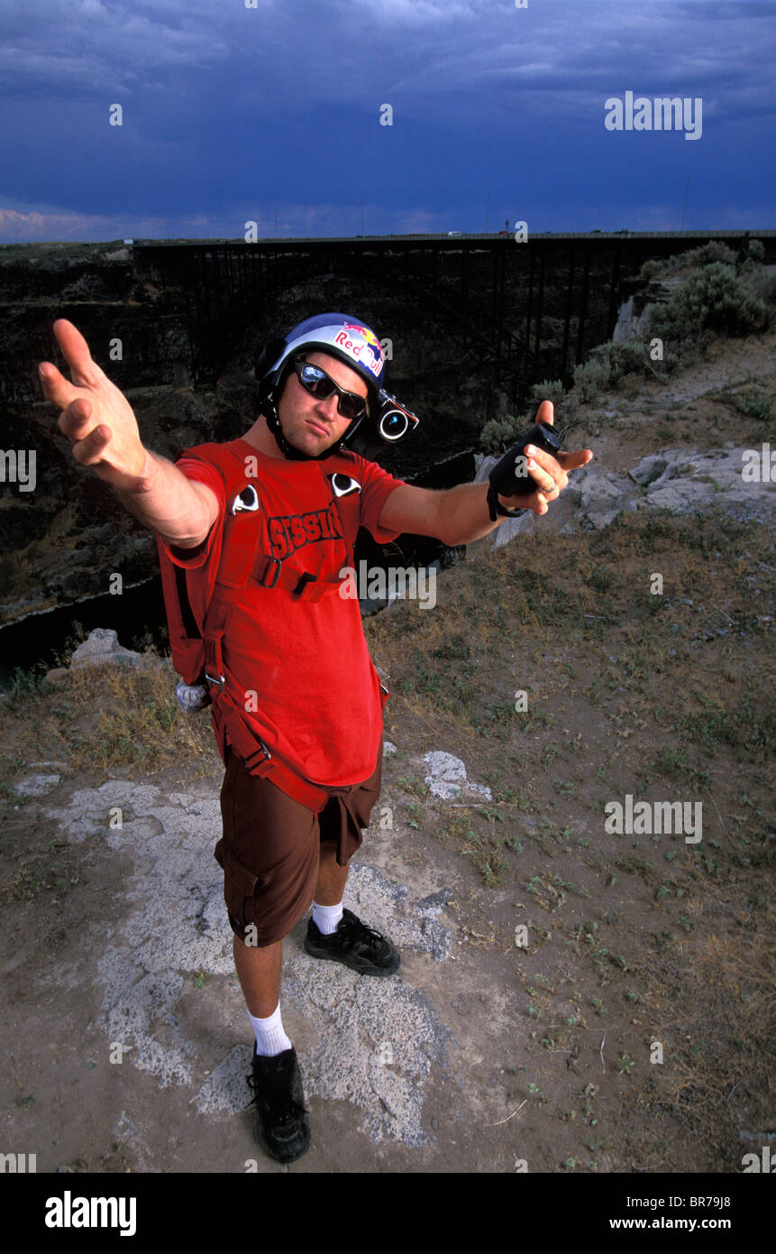 BASE jumper in front of a bridge with a helmet camera and arms out in ...