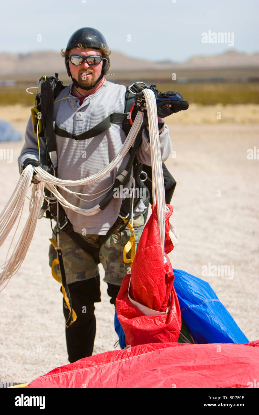 A tandem skydive instructor stands holding his shoot after a successful ...