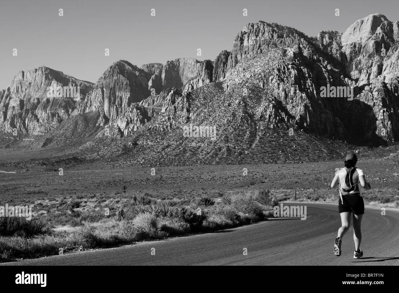 A runner jogs by on the scenic loop road of Red Rocks Canyon Stock ...