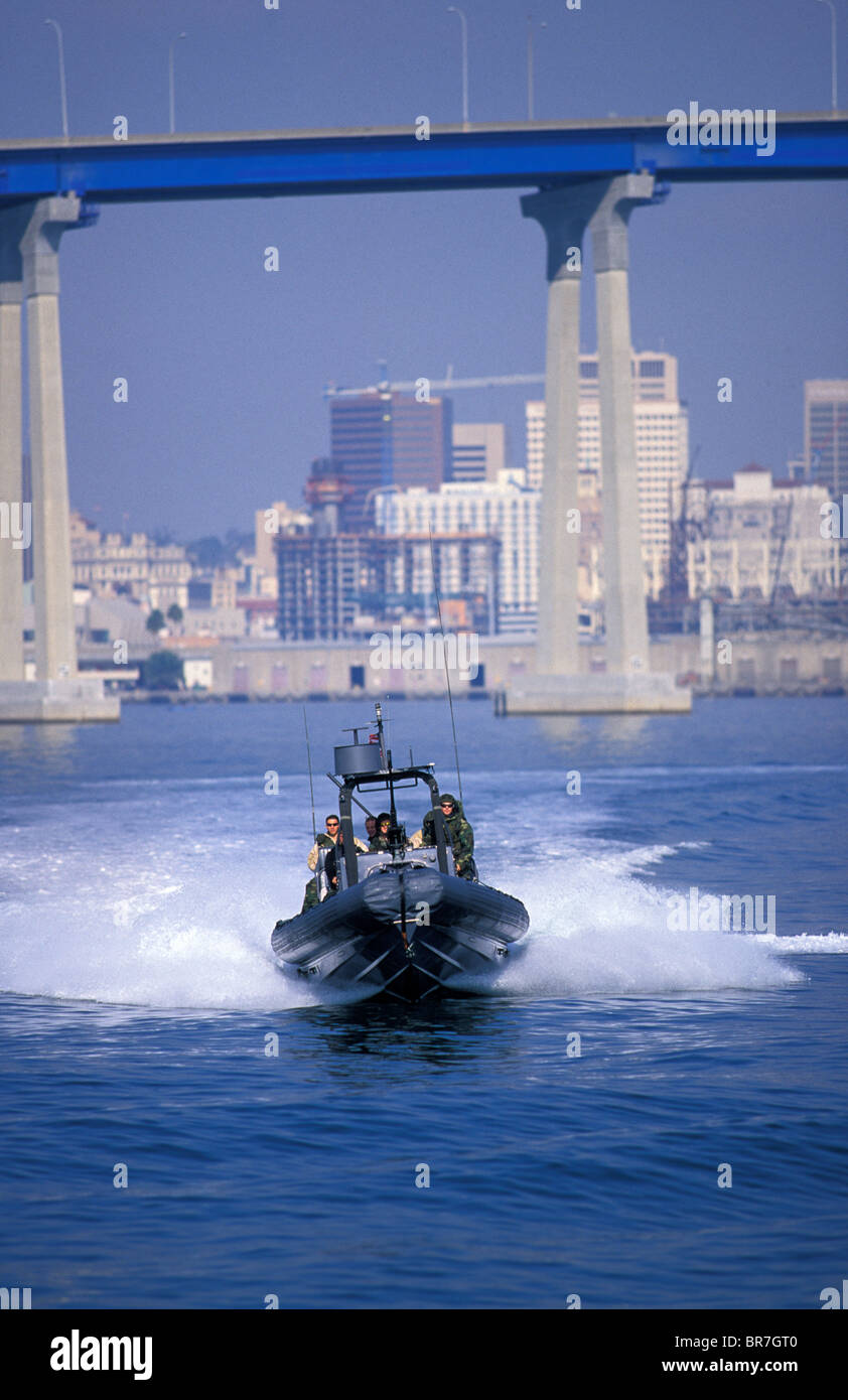 Men in training driving an inflatable boat with guns in San Diego ...