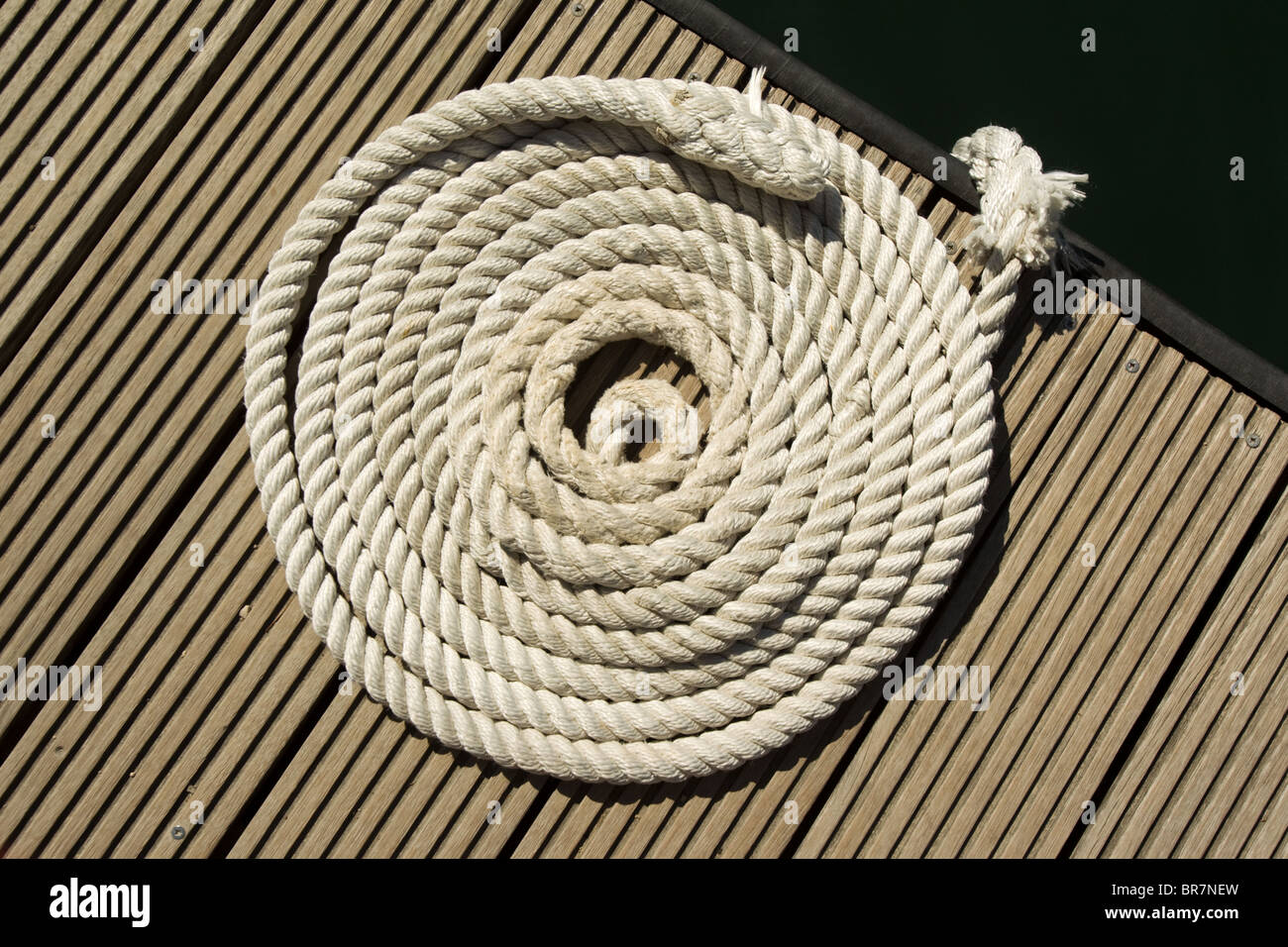 A coiled up Rope on a boat gangway Stock Photo - Alamy