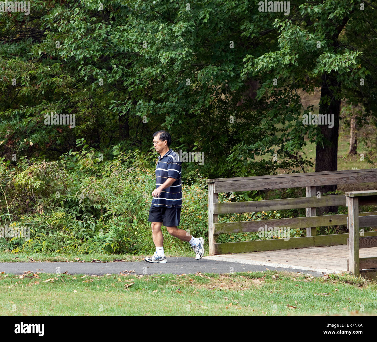 An Asian male senior man out for a morning power walk in the park Stock ...